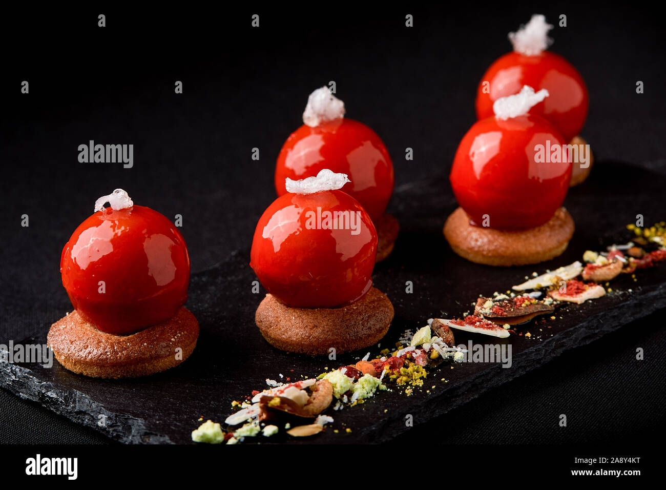 Mini Törtchen aus Beeren verglaste Auf wunderschön auf einer schwarzen ...