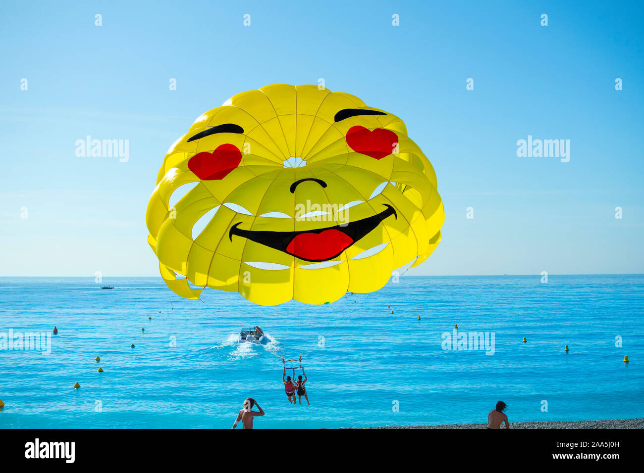 Ein Smiley parasail Fallschirm zieht aus der Strand hinter einem ...