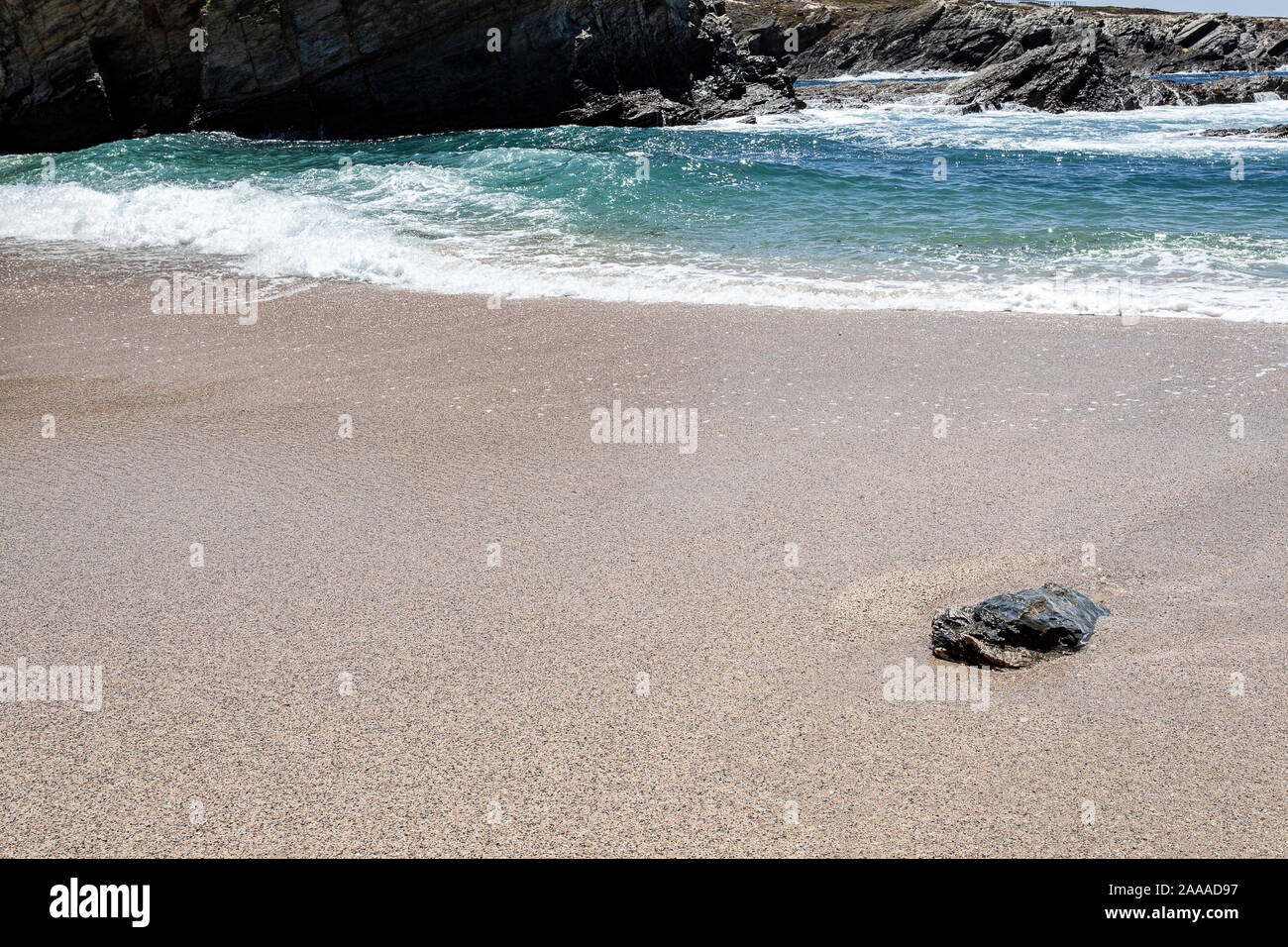 Die Wellen am Strand, die Wellen am Strand, einsame Stein im Sand in ...