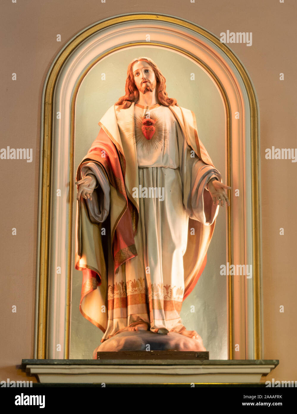 Statue des auferstandenen Jesus Christus mit Pfirsichfarbenen Robe, durchbohrten Hände und Herz ...