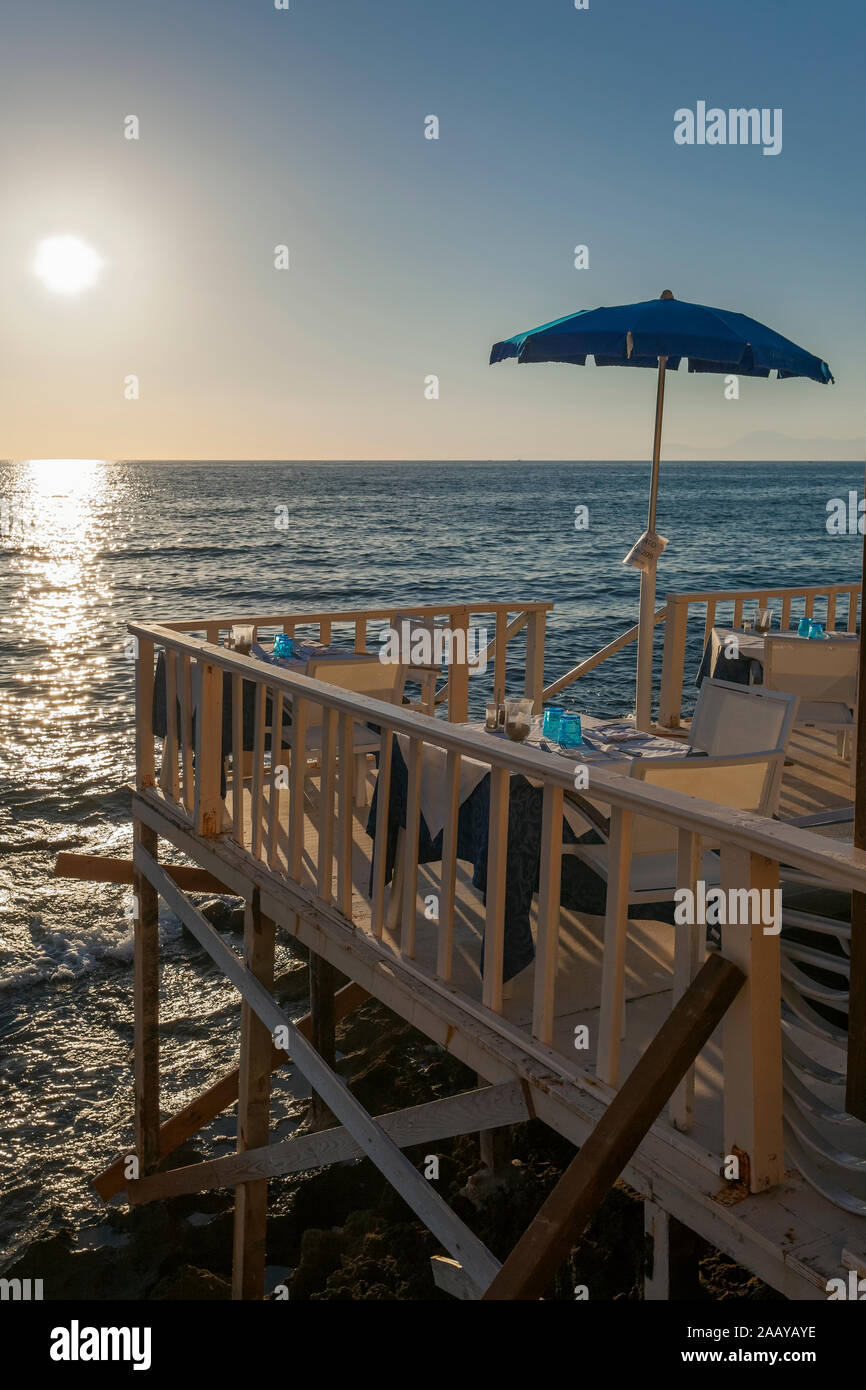Terrasse am Meer mit Tisch, Sonnenschirm und Dinind Tabellen, Strand ...