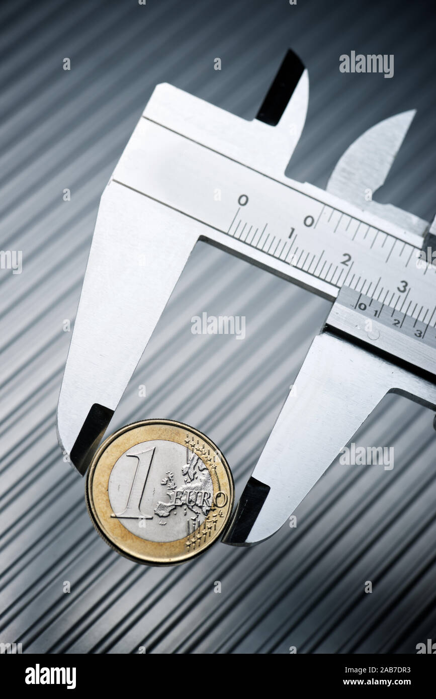 Blechlehre messen einer 1 Euro Münze auf einer Metalloberfläche ...