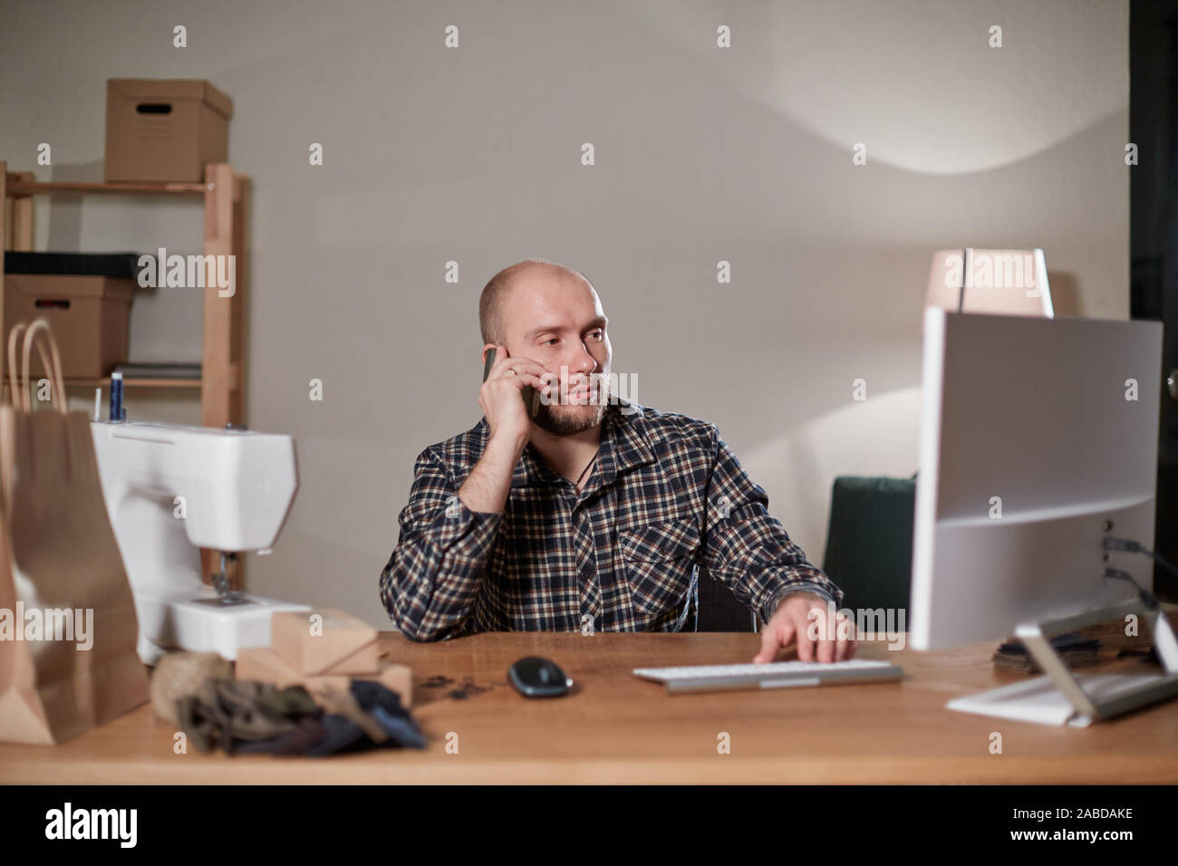 Ernster Mann sprechen per Telefon. Auf dem Computer ist die Lieferung ...