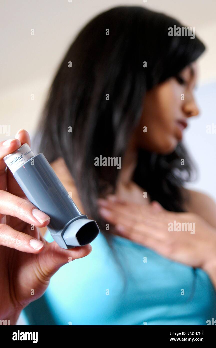 MODEL RELEASED. Asthmaanfall. Junge Frau über einen Inhalator bei einem ...