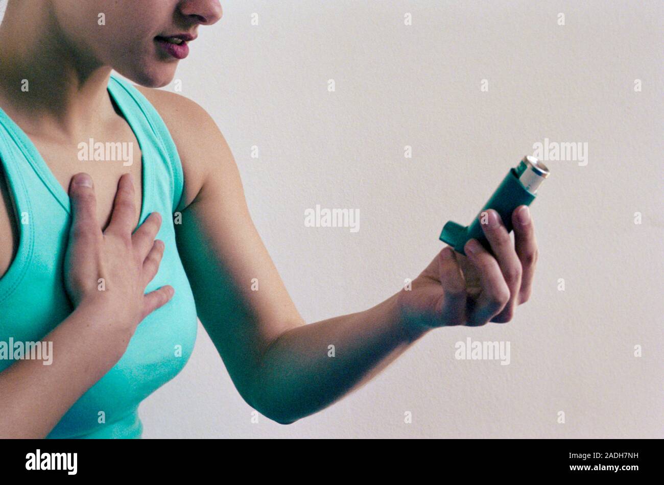MODEL RELEASED. Asthmaanfall. Junge Frau nutzt einen Inhalator einen ...