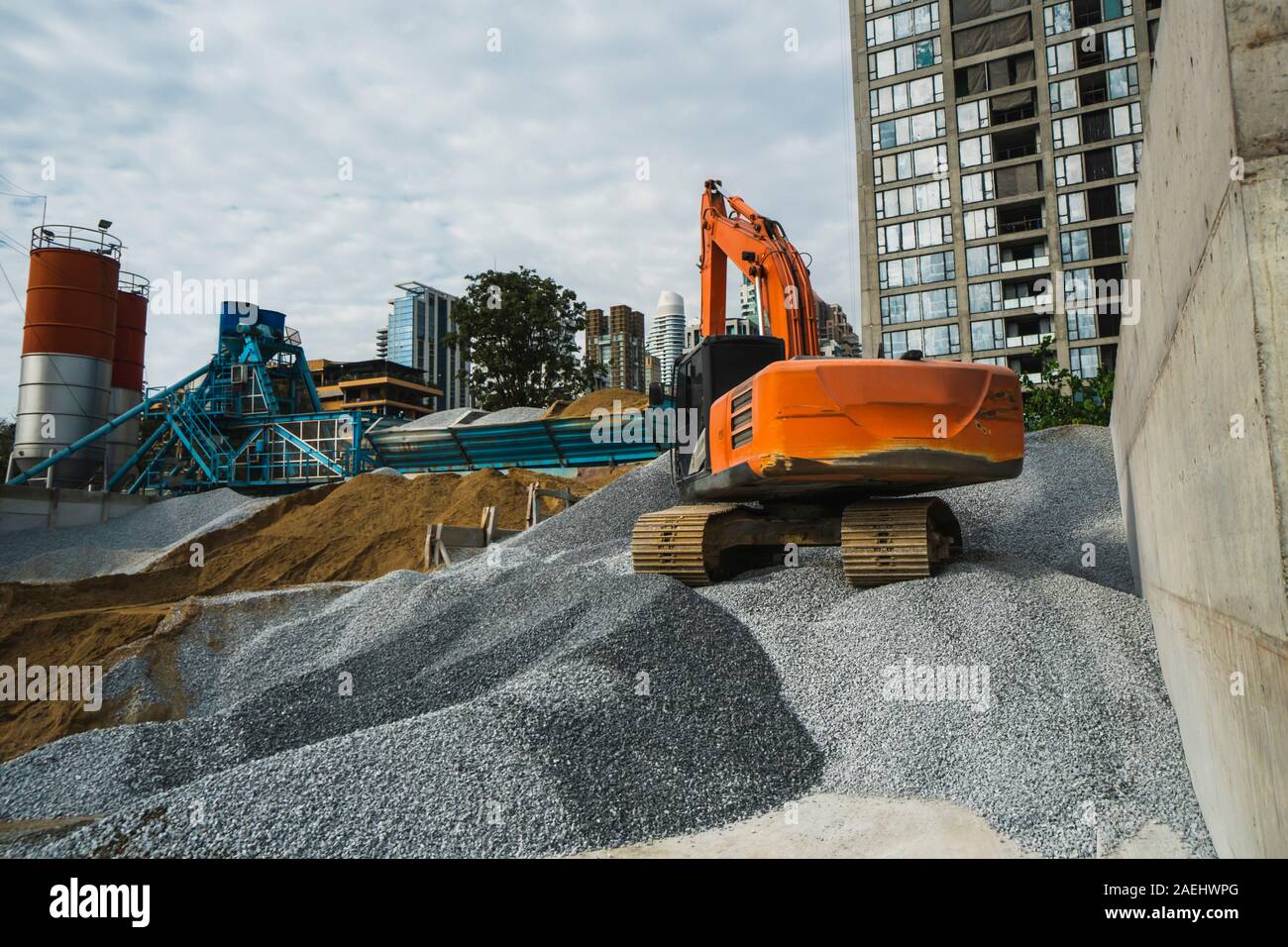 Große orange Bagger arbeiten an einer Kiesgrube auf der Baustelle ...