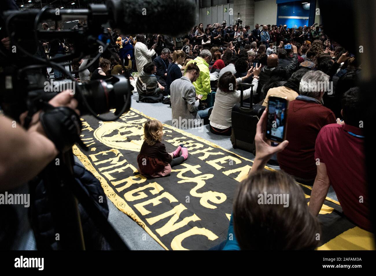 Ein Junge sitzt auf einem Banner während des Protestes. Hunderte von ...