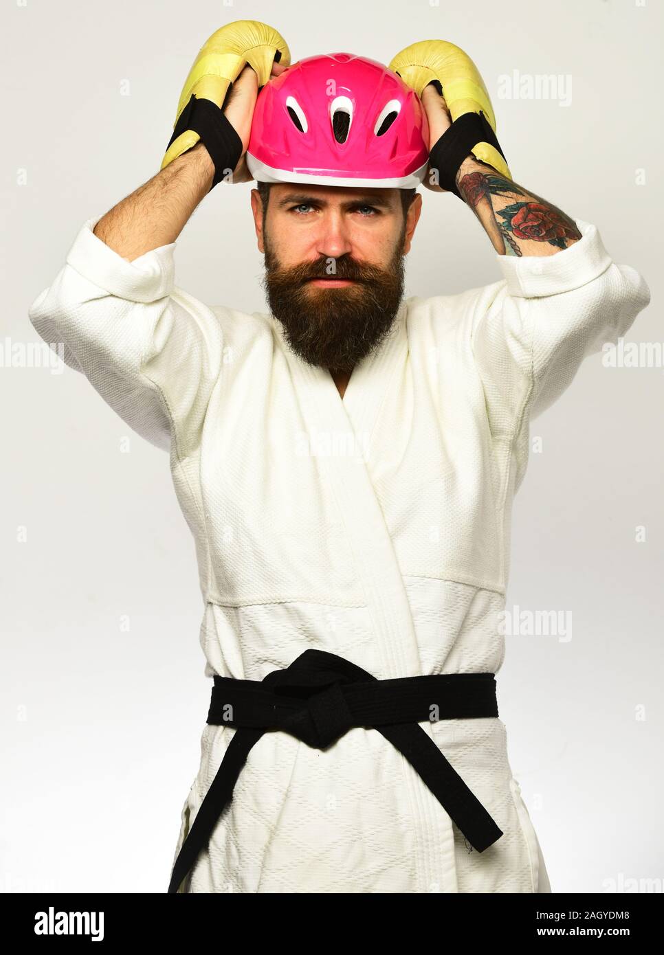 MMA Sport Konzept. Mann mit Bart in weißen Kimono und rosa Helm auf ...