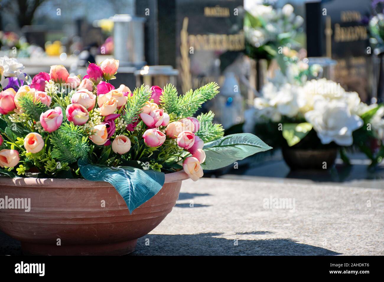 Friedhof in sonniger Tag. Grabstein mit Blumen und Kerzen. Grab ...