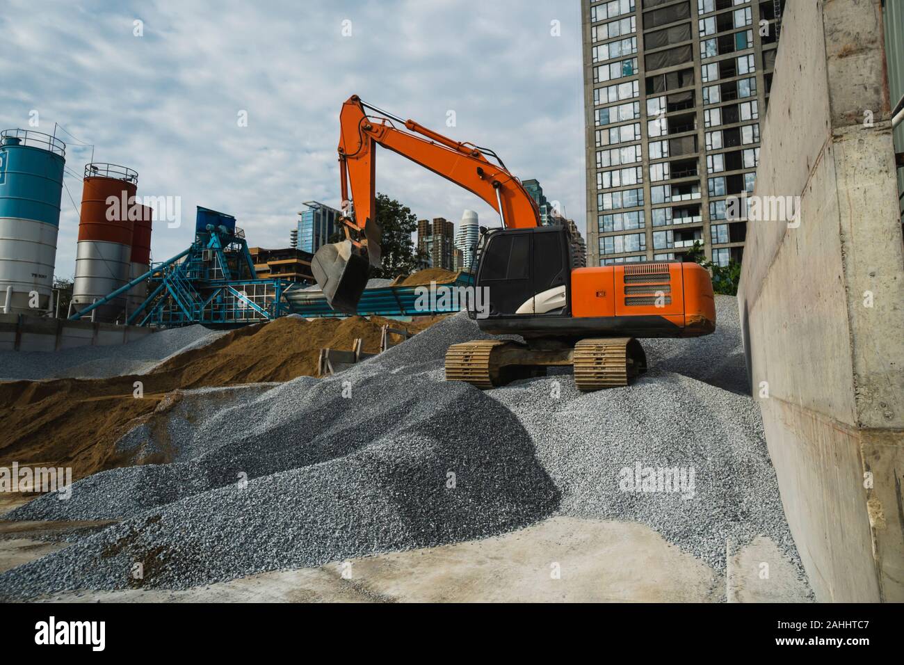 Große orange Bagger arbeiten an einer Kiesgrube auf der Baustelle ...