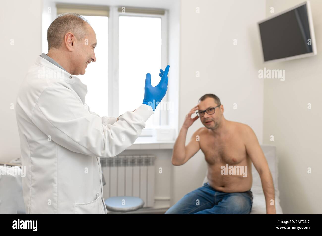 Urologe Arzt setzt auf medizinische Handschuhe vor der Untersuchung ...