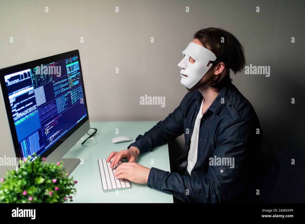Anonymer Computerhacker in weißer Maske und Hoodie. Verdecktes dunkles ...