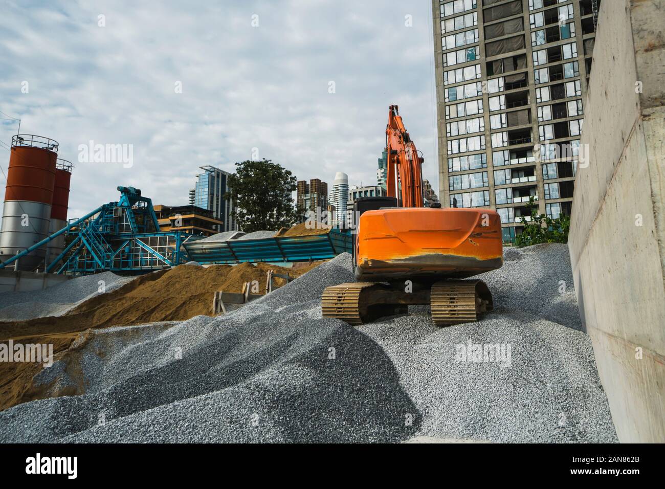 Große orange Bagger arbeiten an einer Kiesgrube auf der Baustelle ...