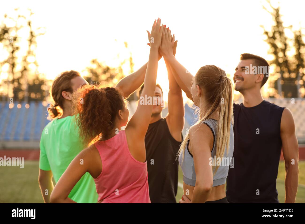 Gruppe der sportliche junge Menschen die Hände zusammen, im Stadion ...