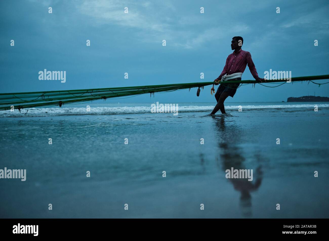 Fischer zieht die Netze am Strand in Sri Lanka aus dem Meer. Die Stadt ...