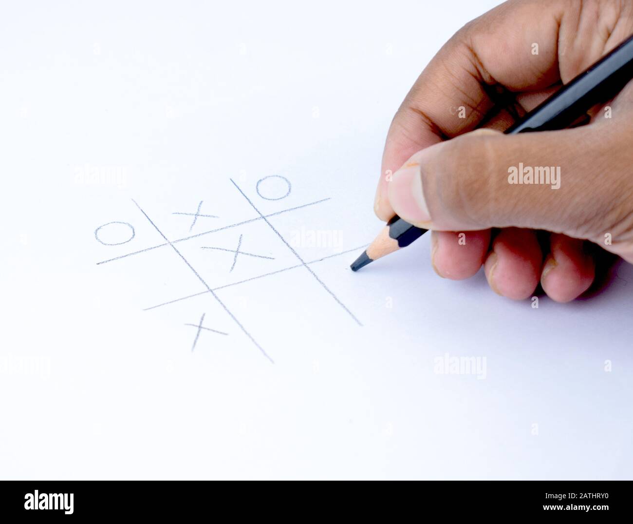 Eine Person, die Tic tac Toe auf einem leeren weißen Papier mit einem ...