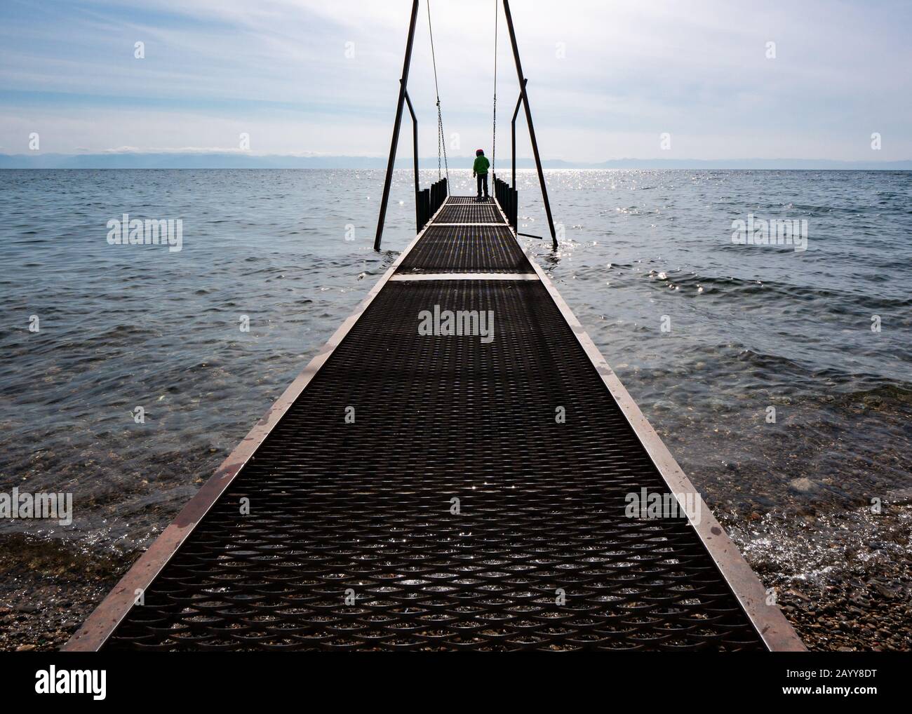 Die Silhouette der Kinder lag am Ende des Stegs aus Metall, am Strand ...