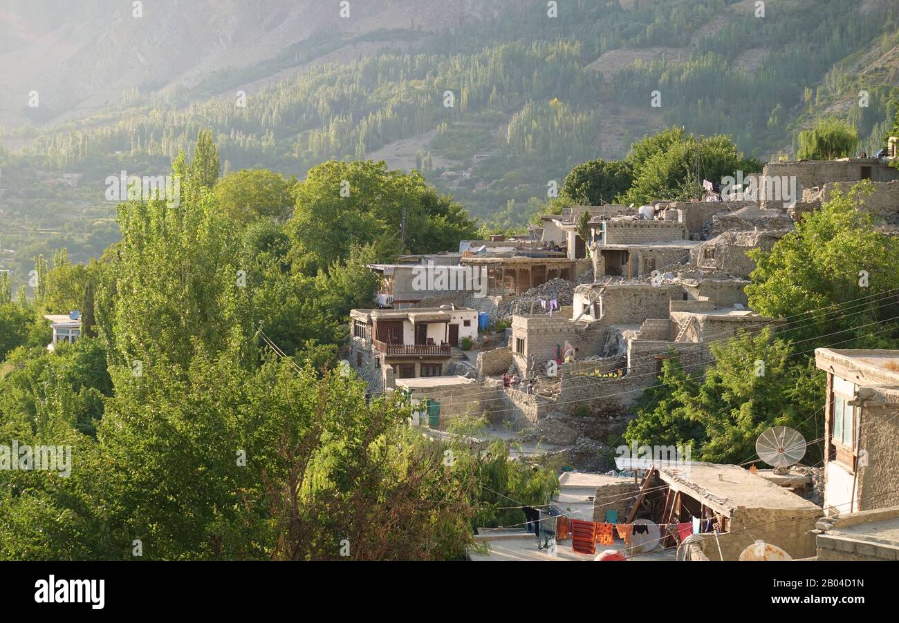 Ein Dorf im Hunza-Tal, umgeben von Bergen und Waldbäumen. Karimabad ...