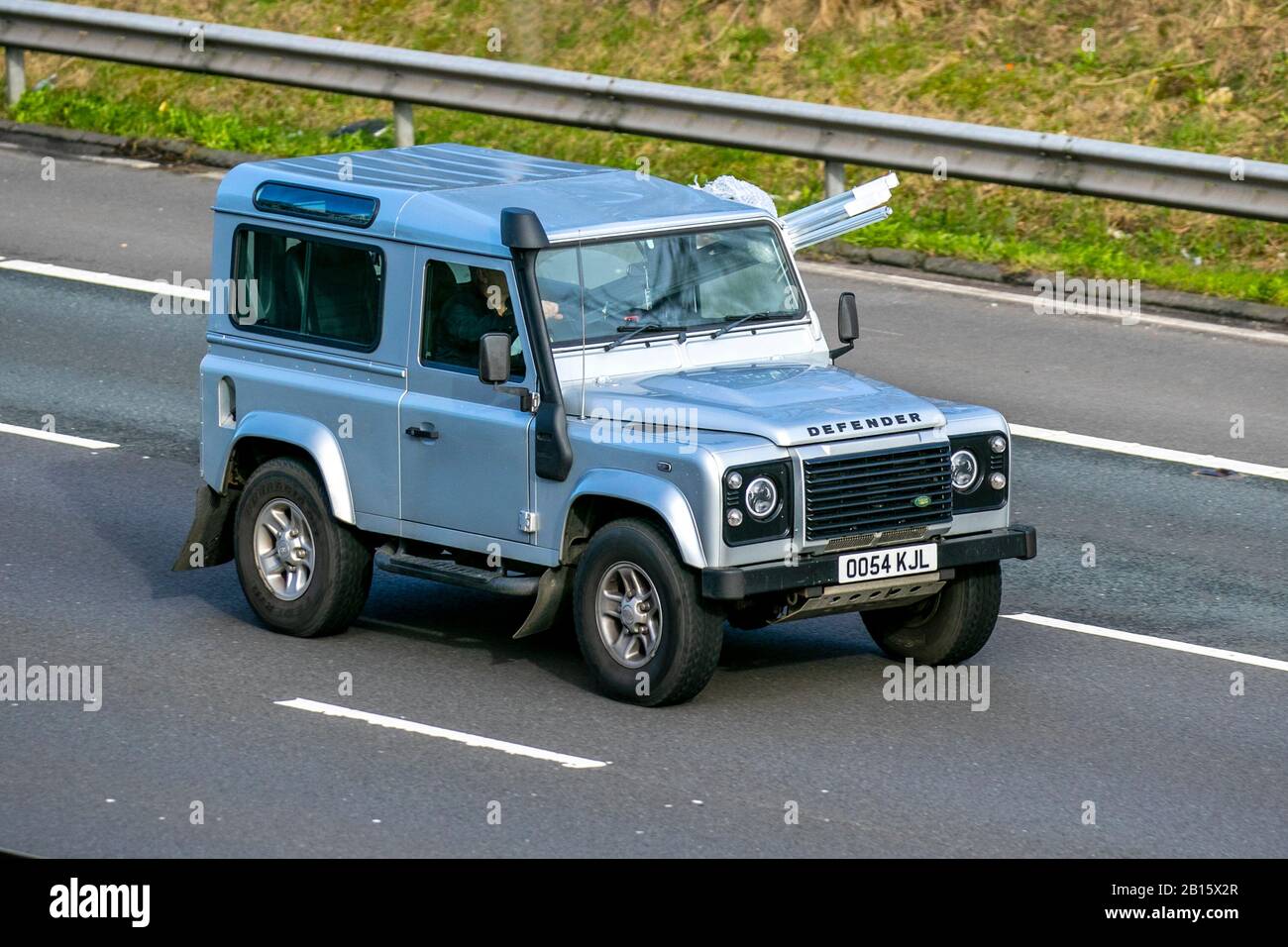 2008 Silber Land Rover Defender 90 XS SW SWB mit Oads Overhanging Side of Vehicle UK Vehicular Traffic Transport modern Salonwagen East bound auf der 3 spurigen Autobahn M6 Stockfotografie Alamy