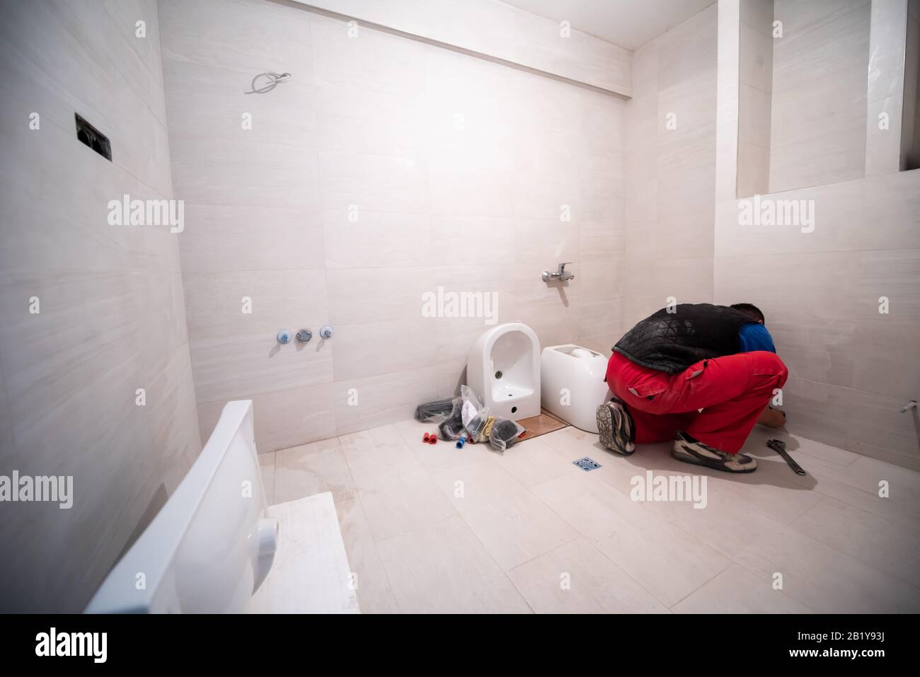 Professioneller Installateur, der in einem Bad arbeitet, Sanitäranlagen ...