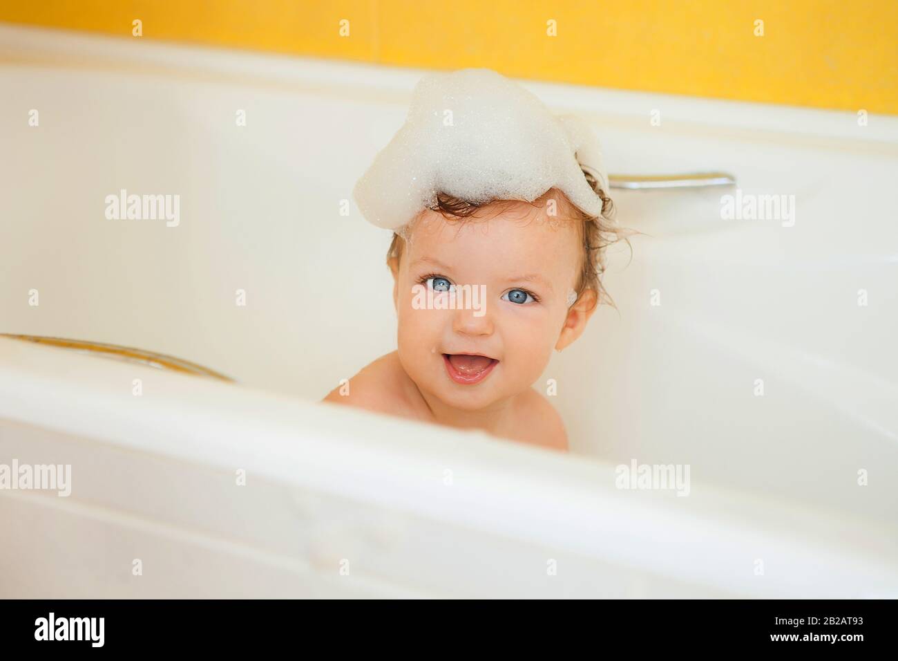 Glückliches Baby, das ein Bad nimmt, lacht und spielt. Lächelndes Kind ... Glückliches Baby, das ein Bad nimmt, lacht und spielt. Lächelndes Kind ...