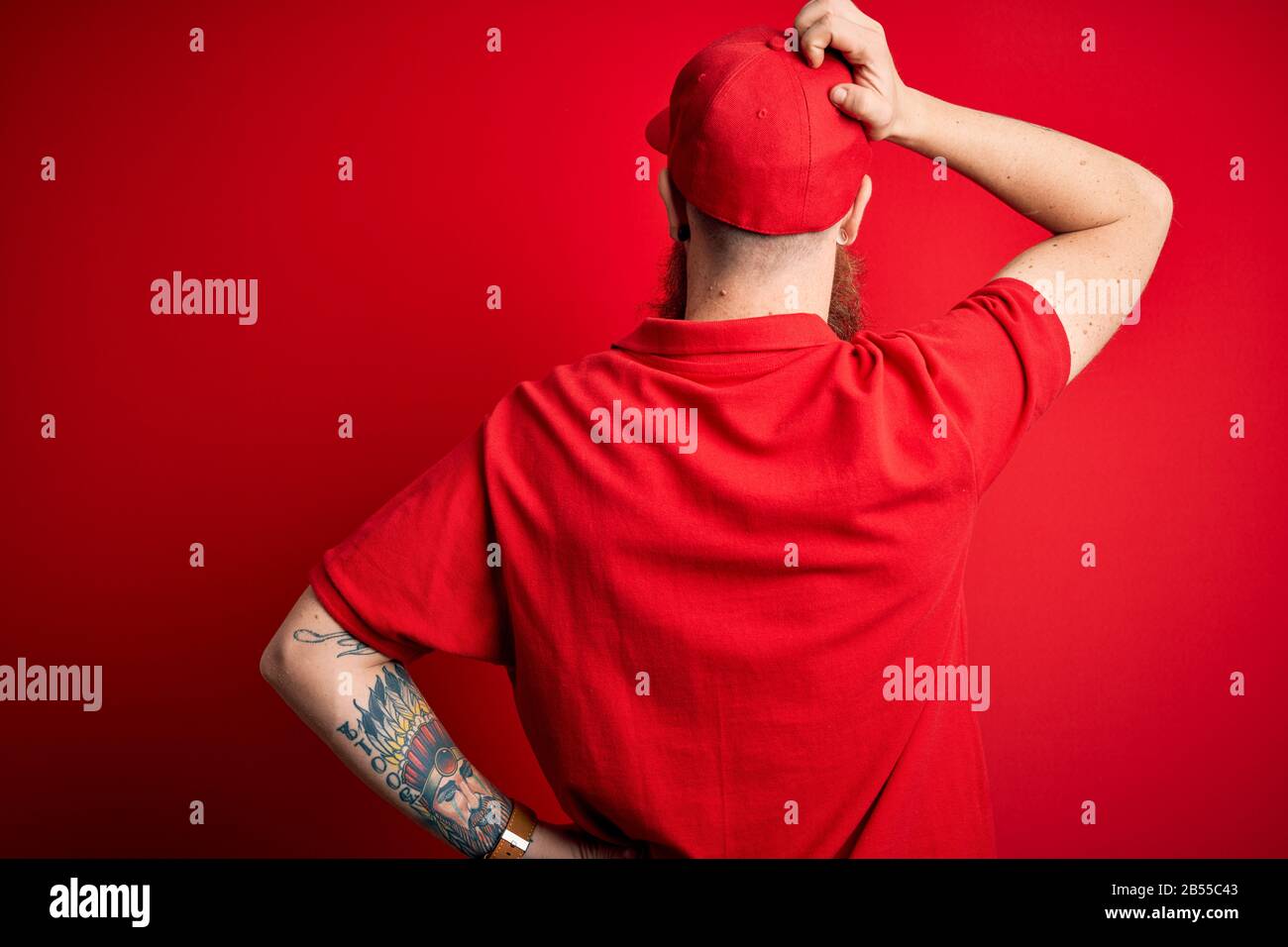 Junger, gutaussehender Mann, der Brille und rote Kappe über isoliertem ...