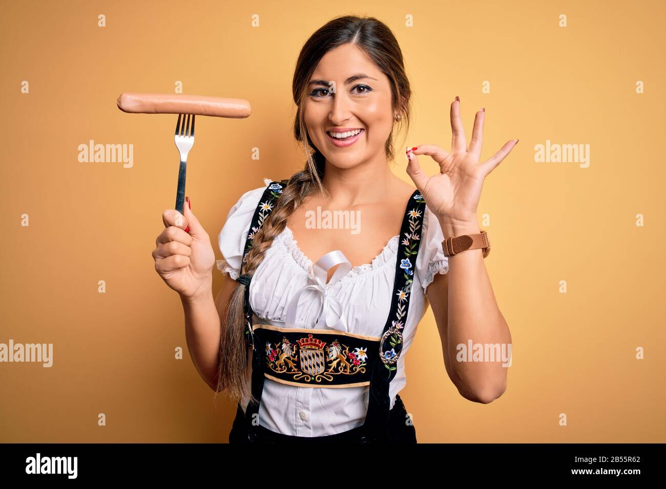Junge brünette deutsche Frau mit traditionellem Oktoberfestkleid, Wurst ...