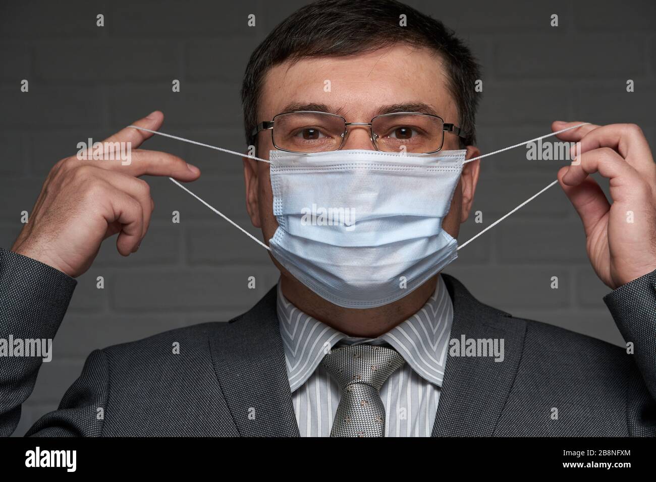 Ein Mann stellt eine Maske auf sein Gesicht, um individuellen Antivirenschutz zu gewährleisten ...