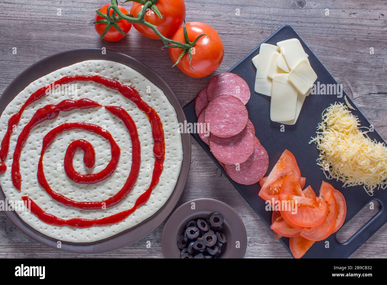 Pizza zu Hause kochen. Pizzabasis und Zutaten für die Zubereitung ...