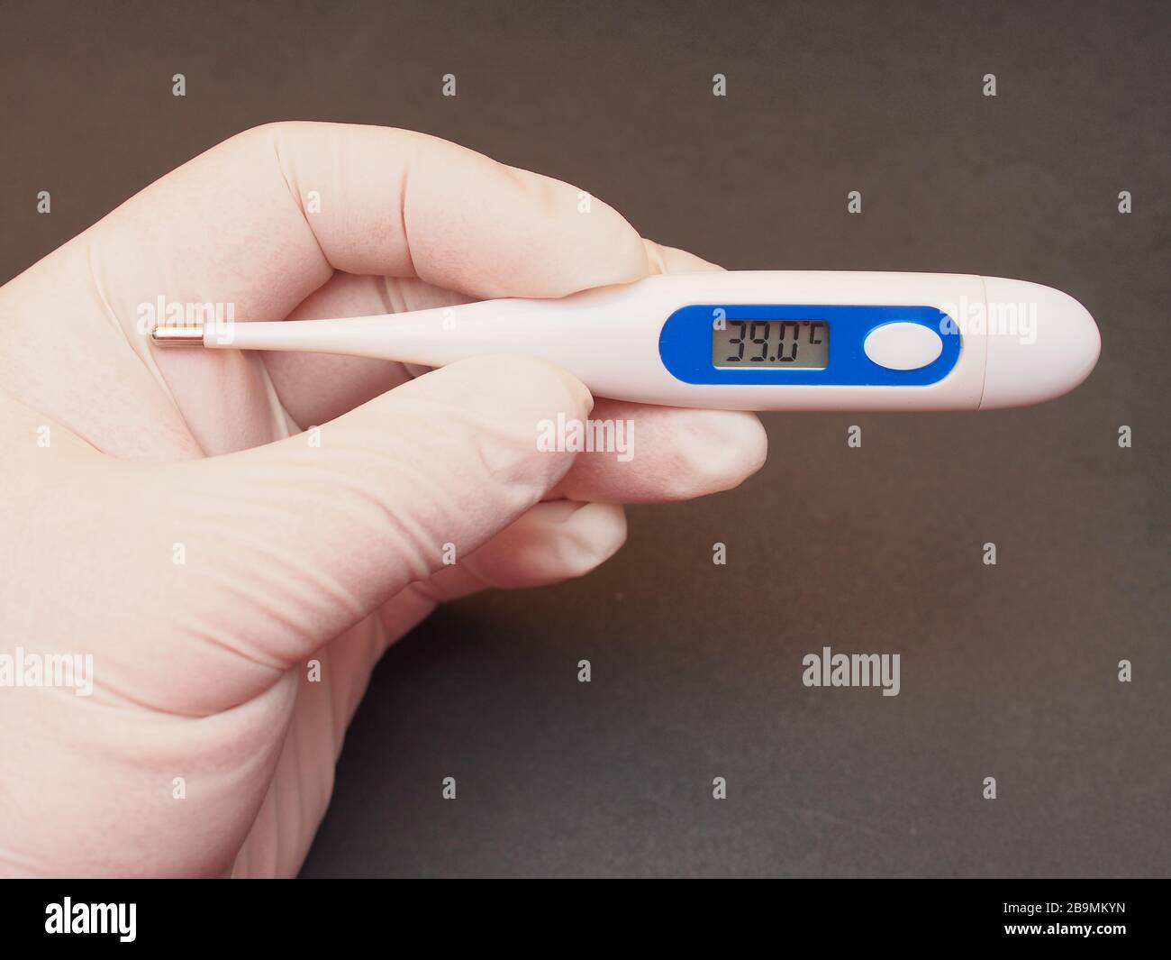 Das elektronische Thermometer wird von einer Hand in einem ...