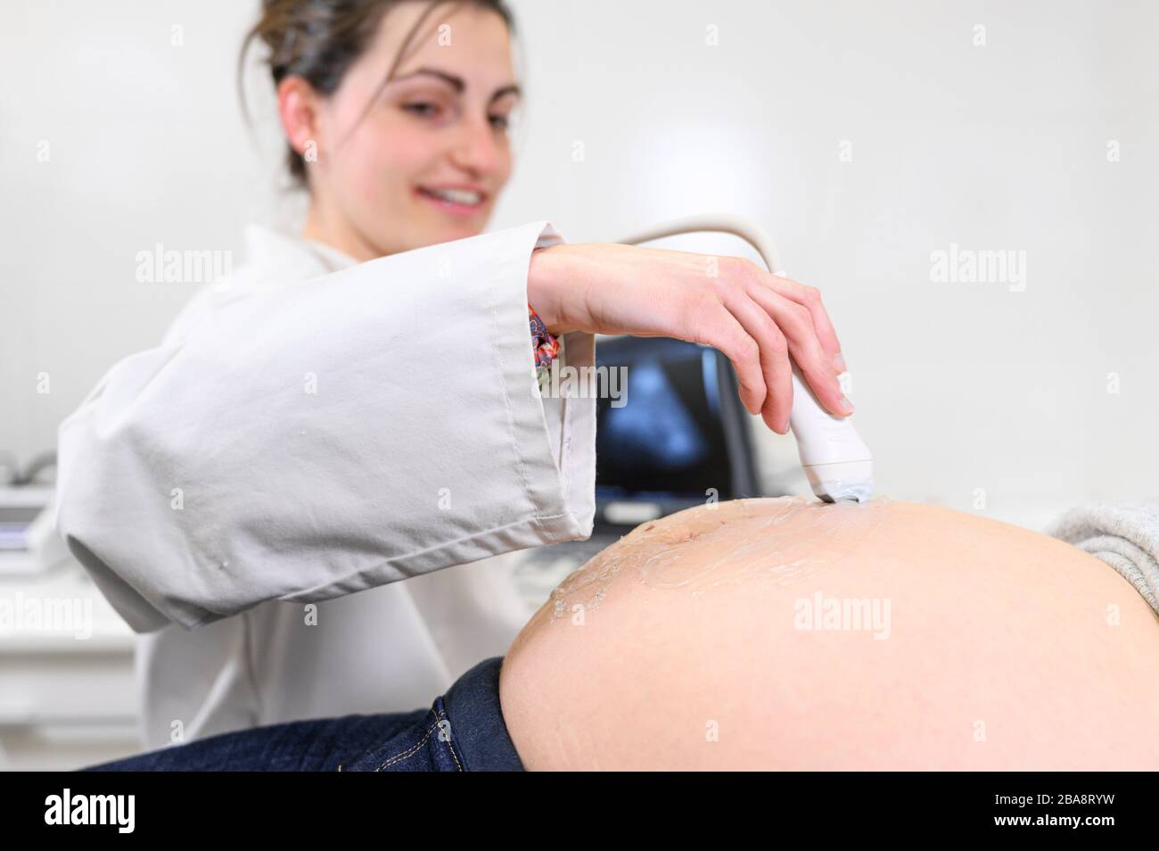 Der Arzt führt Ultraschall- oder Sonogramm-Verfahren an eine Schwangere ...