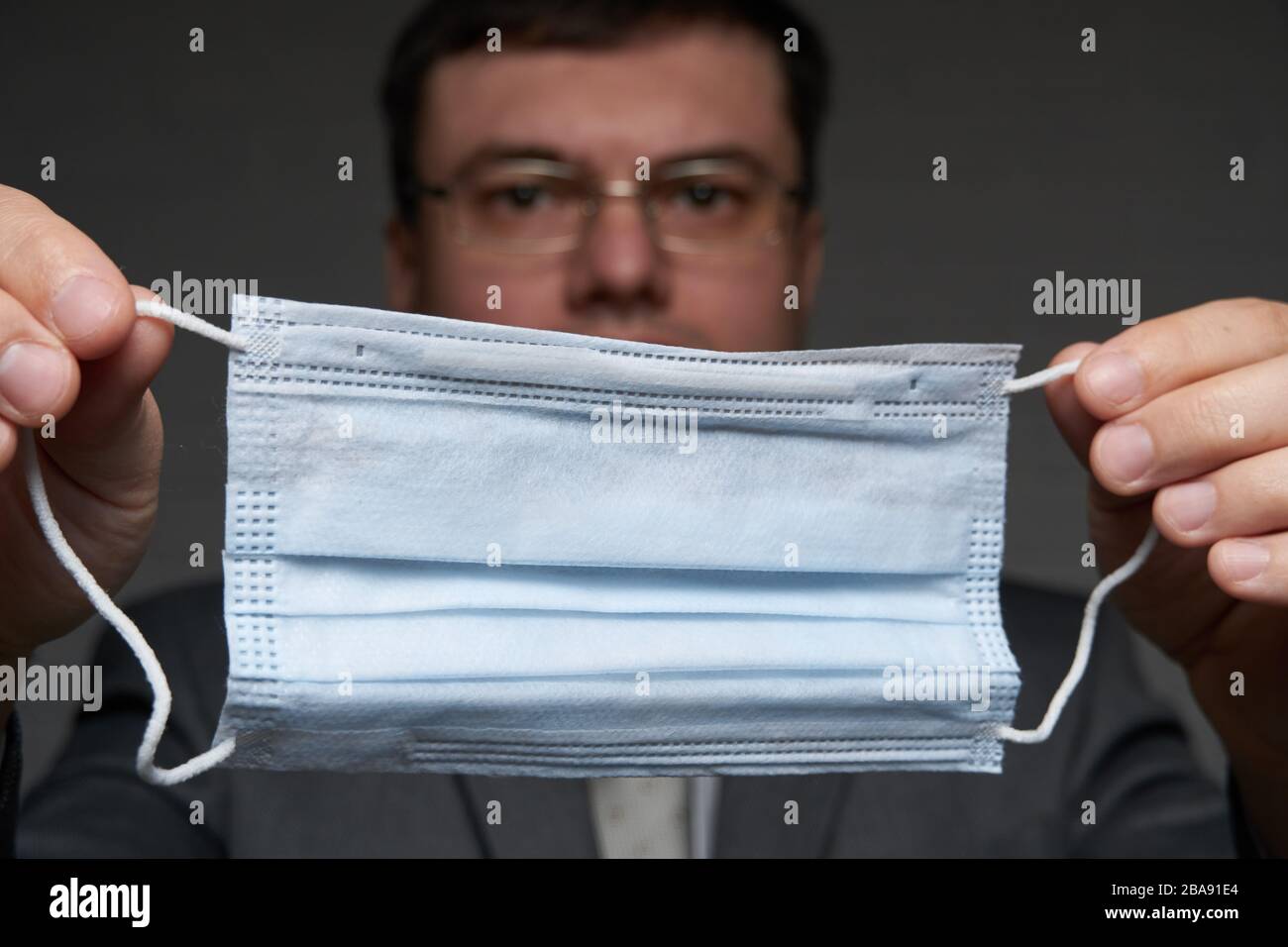 Ein Mann zeigt eine schützende Gesichtsmaske für den individuellen Antivirenschutz - Konzept für ...