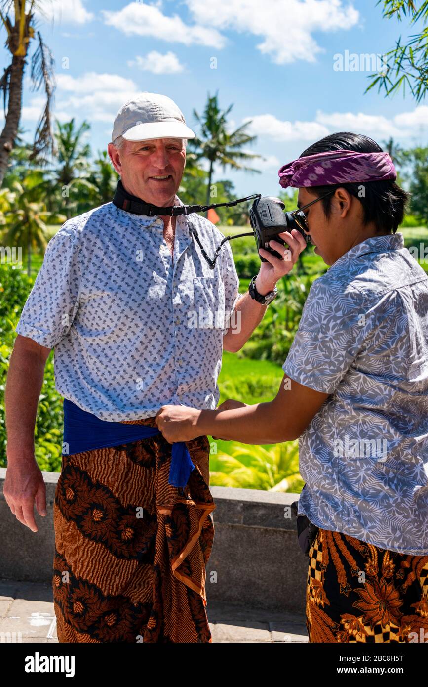 Vertikales Porträt eines Touristen, der einen Sarong von einem ...