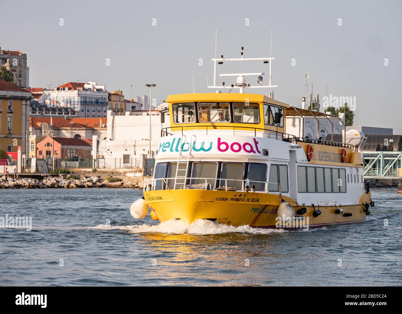 Lisboa Ferry. Ein gelbes Schiff mit Bootstour, das von seinem Dock bei ...