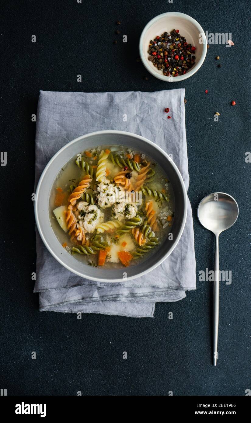 Gesunde Suppe mit Spinat Pasta und Fleischbällchen auf dem Tisch mit ...
