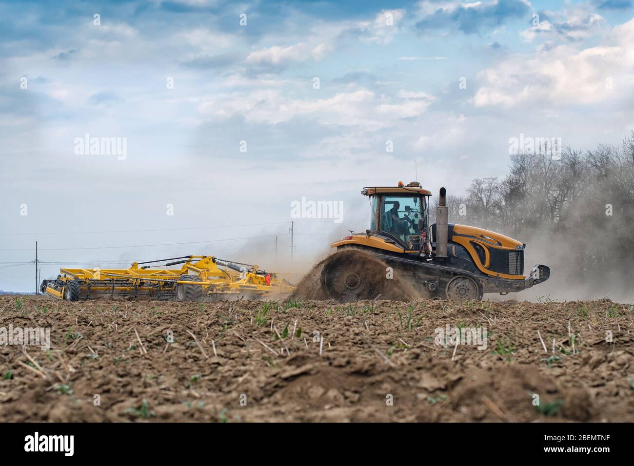 Der Traktor auf dem riesigen Feld, ein Bauer, der einen Traktor fährt ...