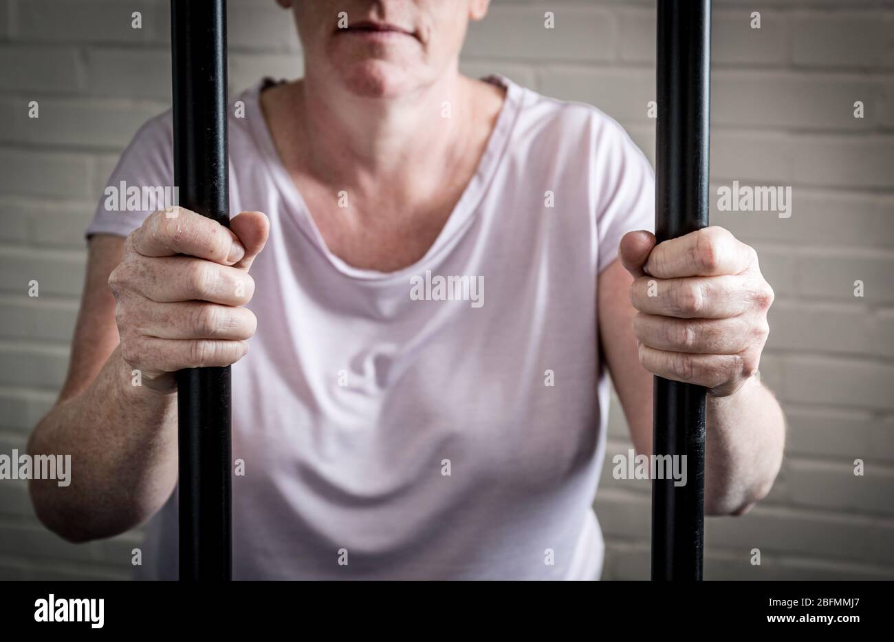 Eine weibliche Gefangene hinter Gittern in einem Frauengefängnis. Bild nach Modell gestellt ...