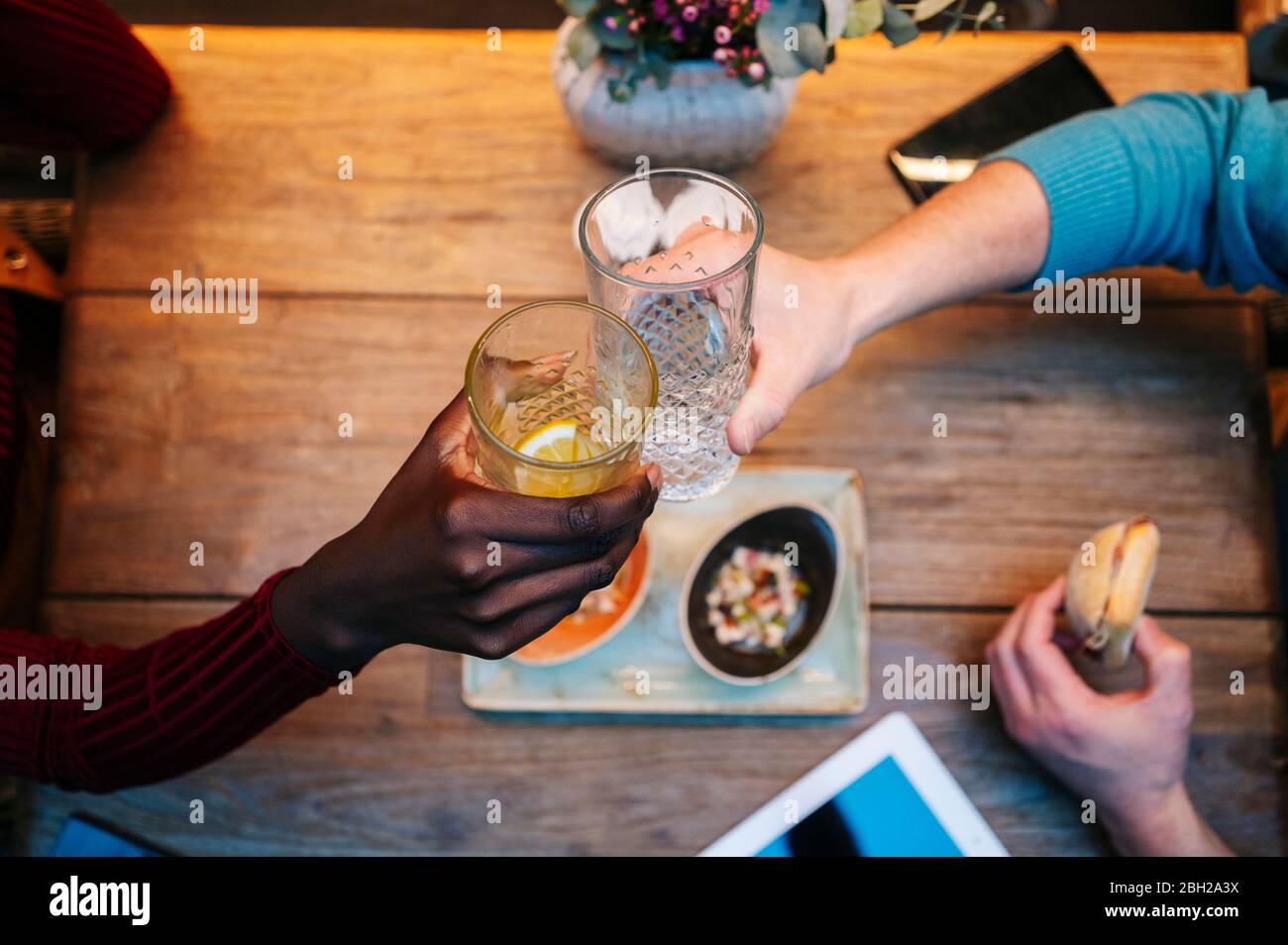Zwei Personen sitzen im Restaurant, essen und trinken, mit digitalem ...