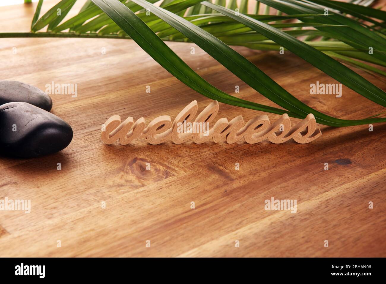 Wellness-Schild mit Holzbuchstaben mit Blättern und Steinen. Relax ...