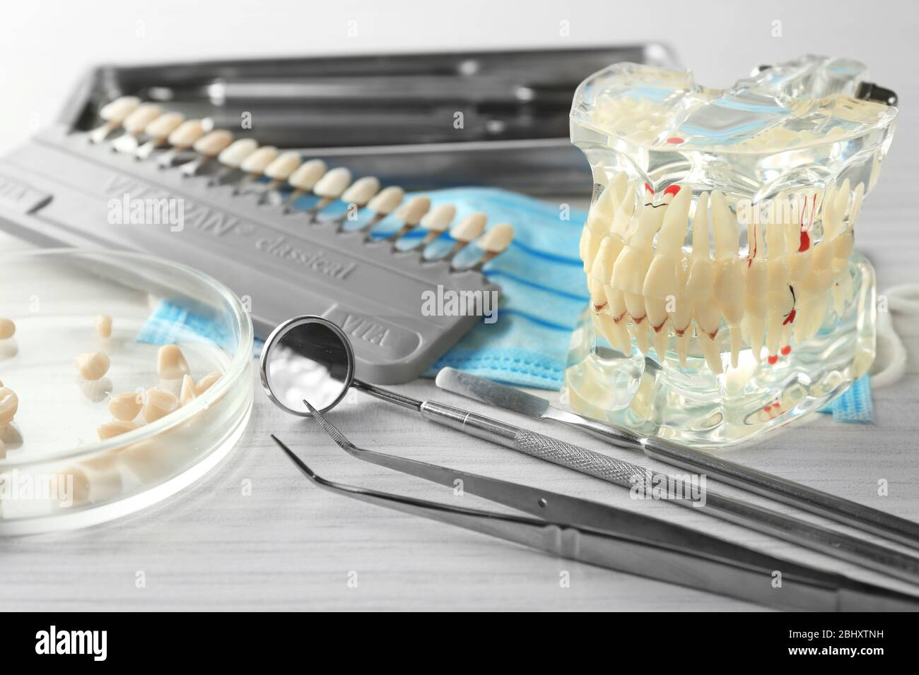 Zahnersatz, Prothese und zahnärztliche Instrumente auf Tischhintergrund ...