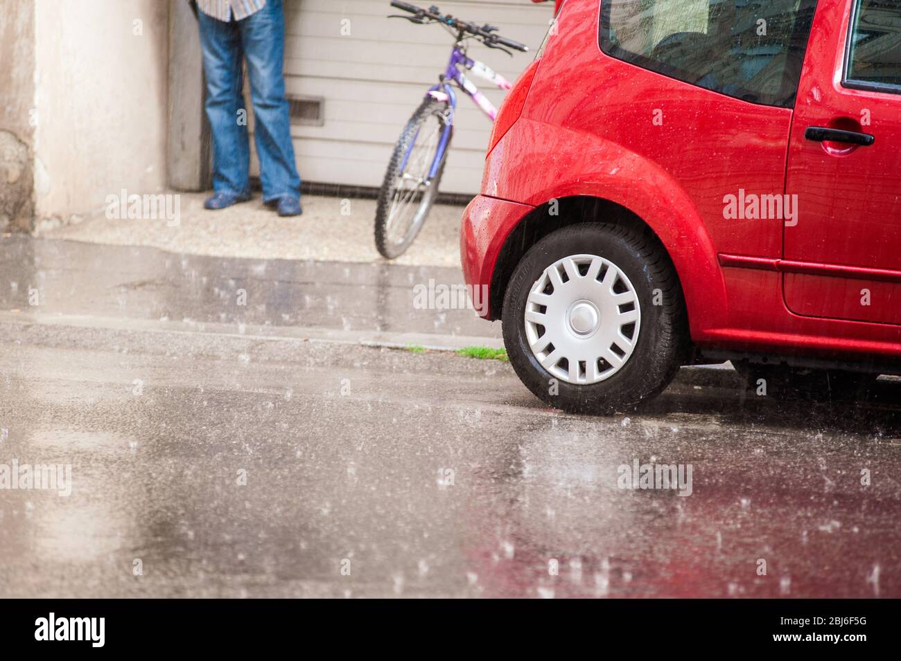 Regnerisches Wetter mit mehreren Regentropfen auf dem nassen Asphalt ...