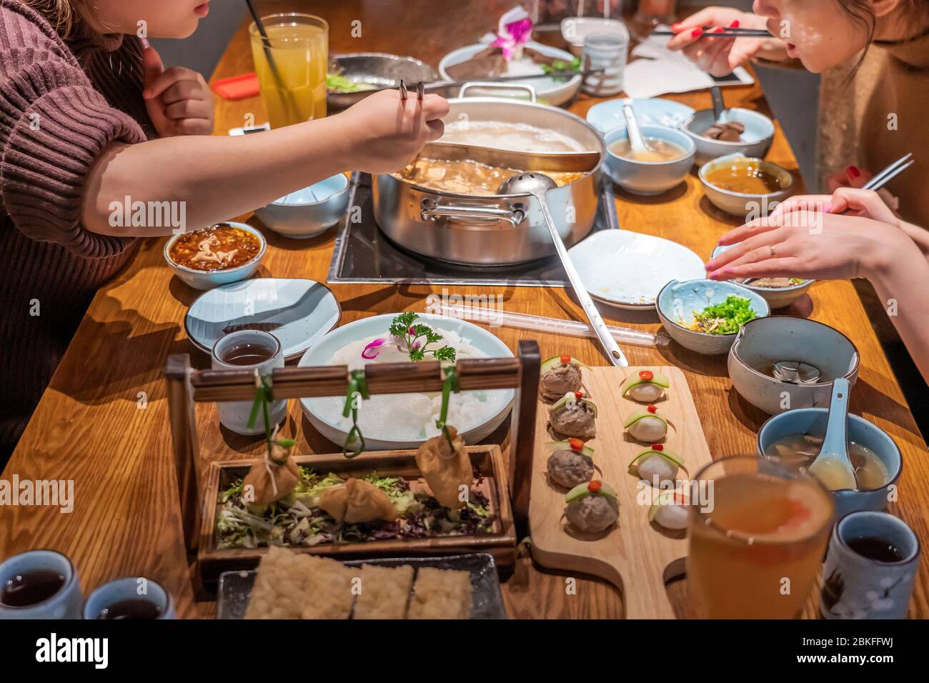 Tisch voller Gerichte und Zutaten, die im Hotpot-Restaurant mit drei ...