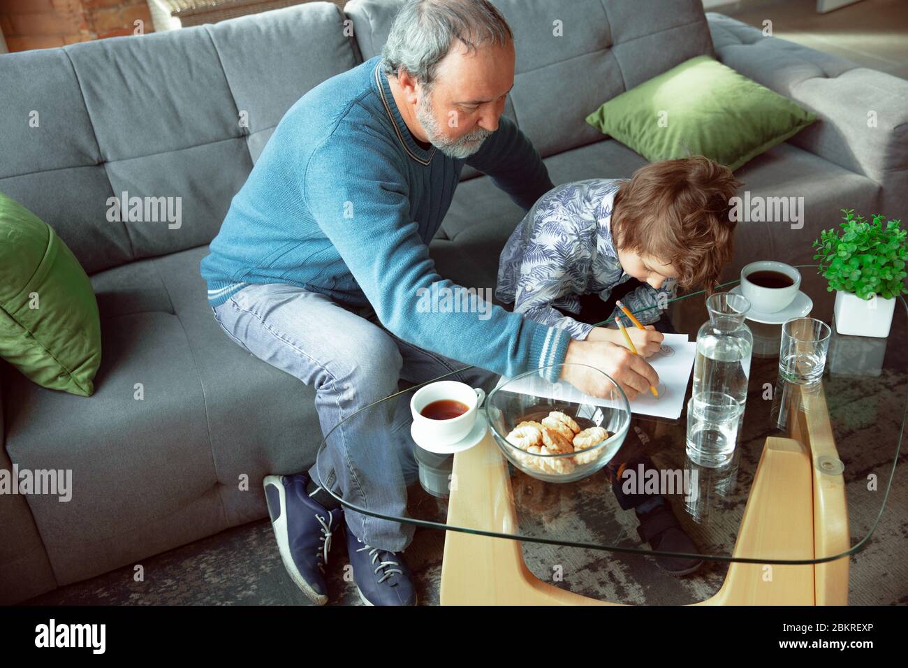 Nützliche Zeit. Großvater und sein Enkel verbringen Zeit zusammen isoliert zu Hause. Spaß haben ...