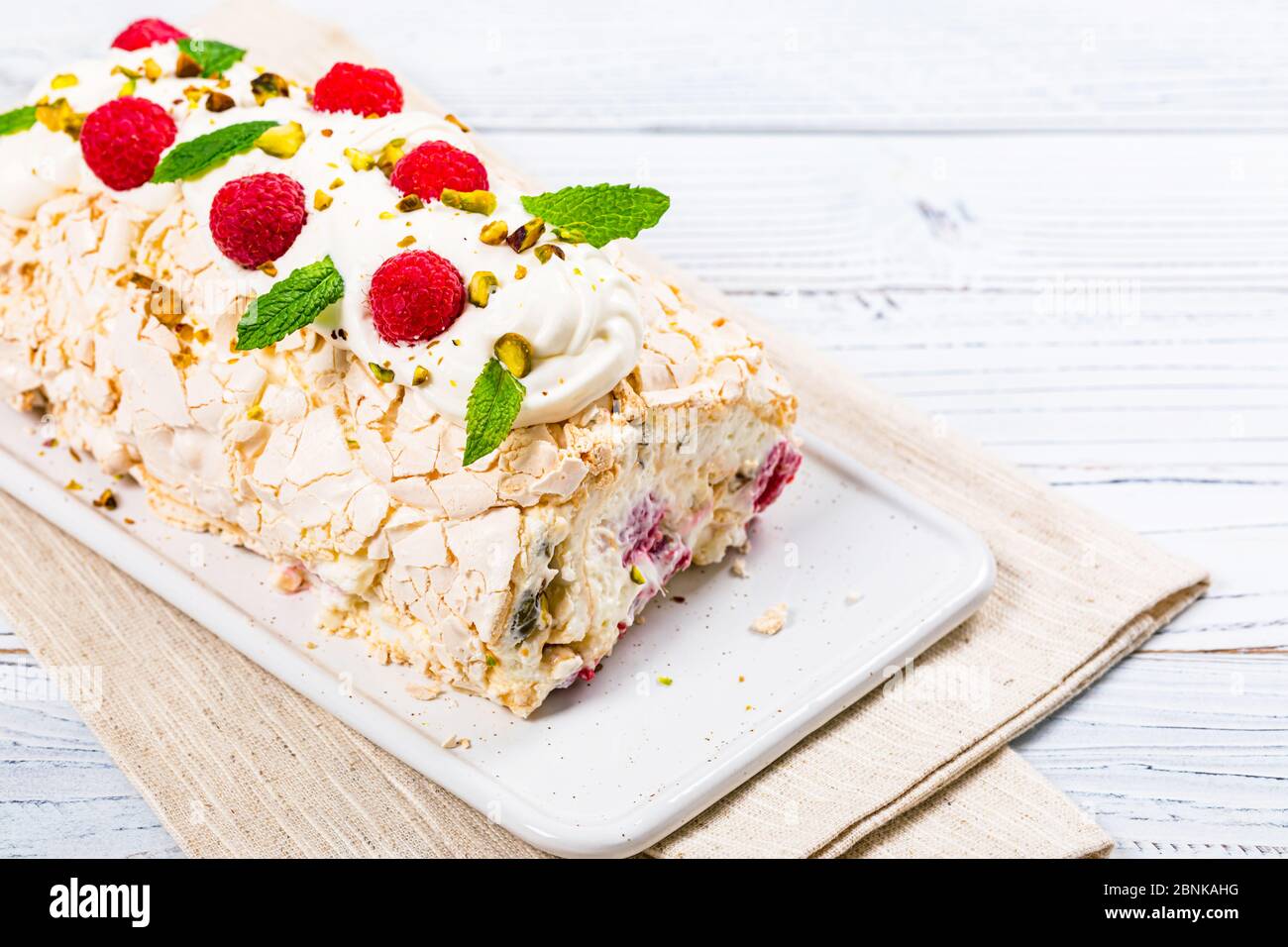 Baiser-Roll-Kuchen Pavlova mit Sahne und Himbeeren. Meringue Roulade ...