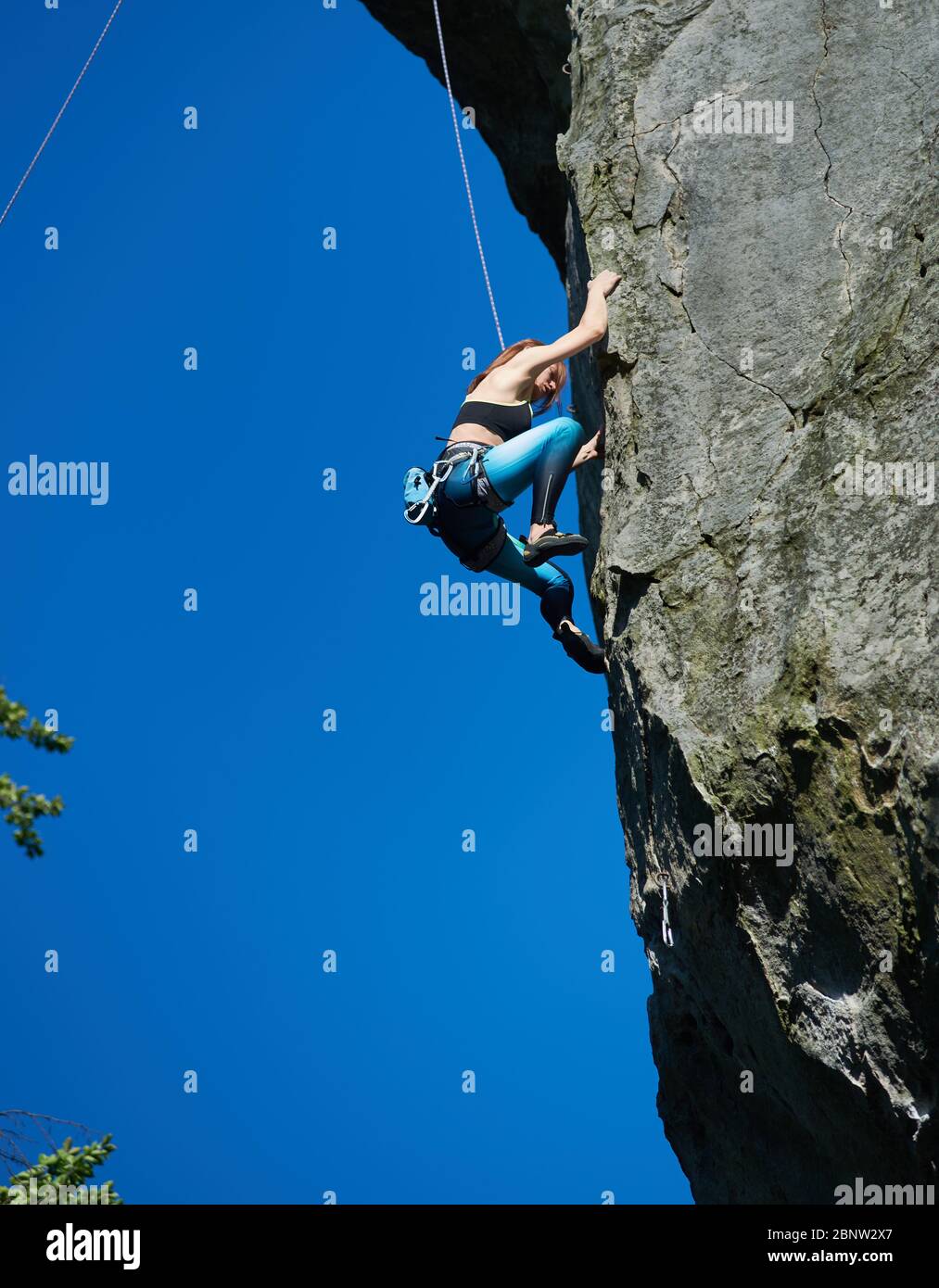 Lady Bergsteiger in Sportbekleidung Klettern Felsen unter blauem Himmel ...