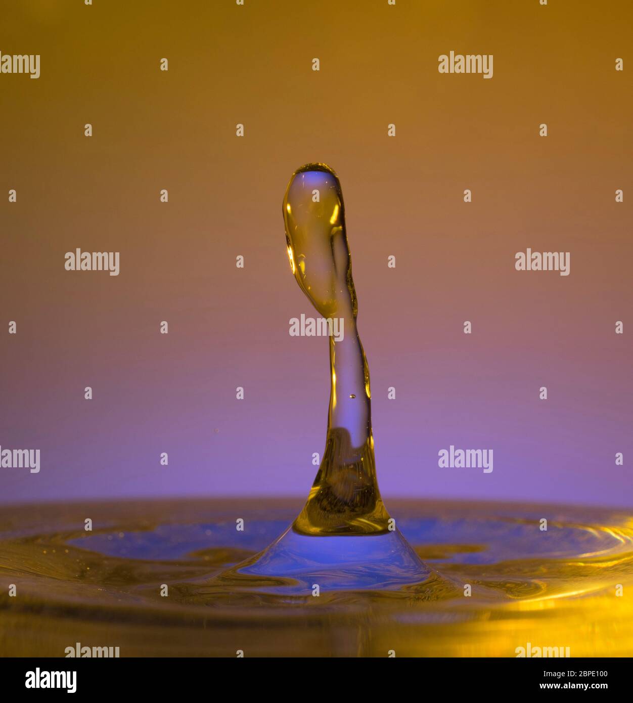 Fallende Wassertropfen vor farbigem Hintergrund bilden eine Form ...