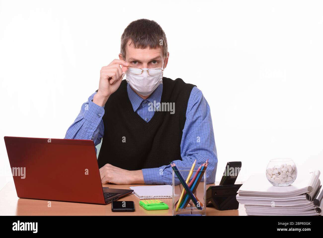 Der Angestellte in einer medizinischen Maske senkte seine Brille von ...