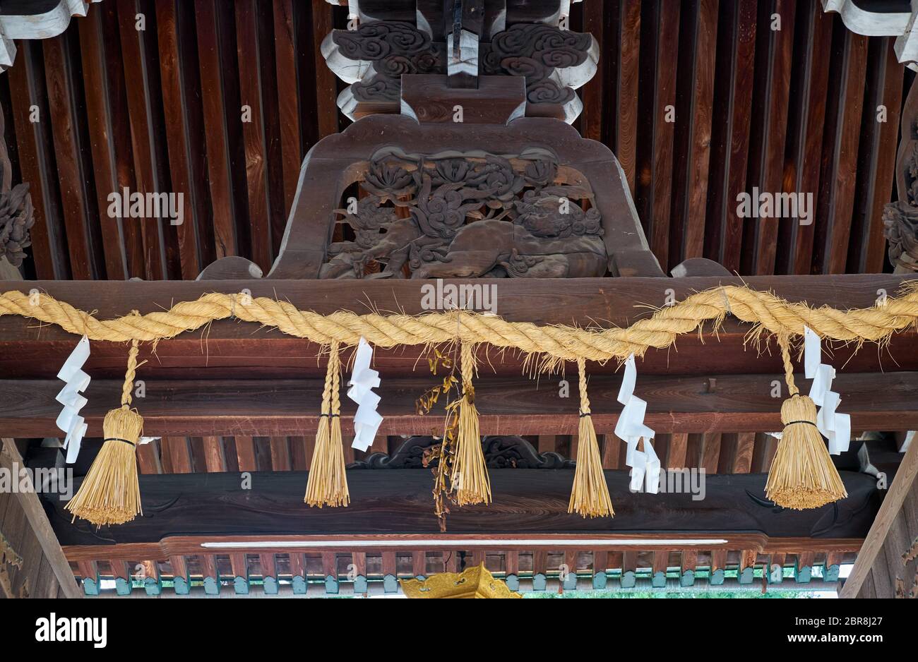 Ein Shimenawa, das Strohseil mit weißen Zickzack-Papierstreifen (shide ...