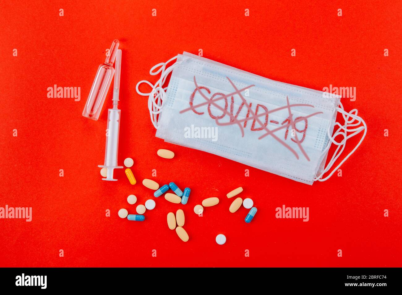 Medizinische Schutzmaske mit der Aufschrift Covid-19, Spritzen ...