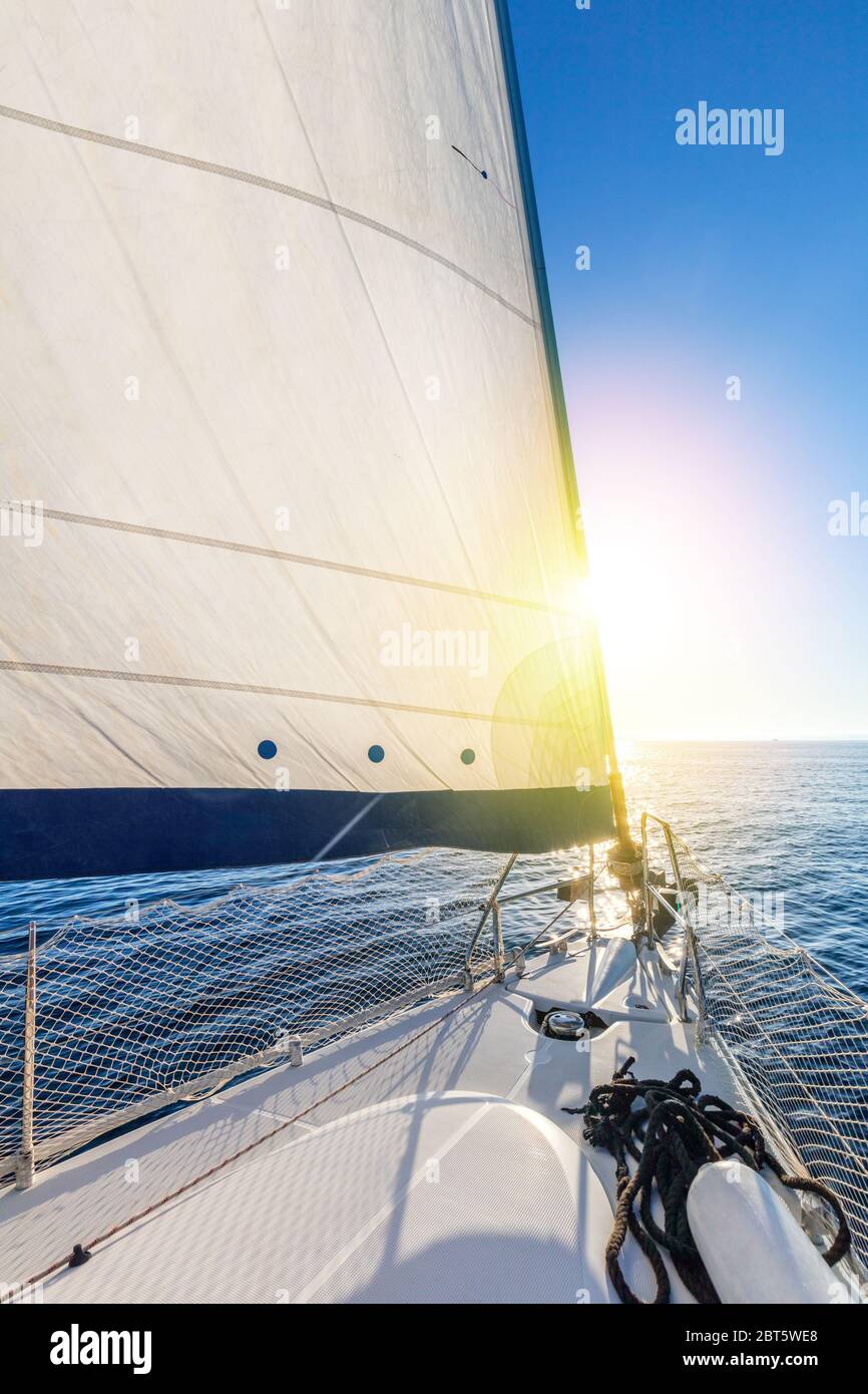 Segeln mit der Sonne. Blick vom Deck der Yacht auf den Bug und die ...